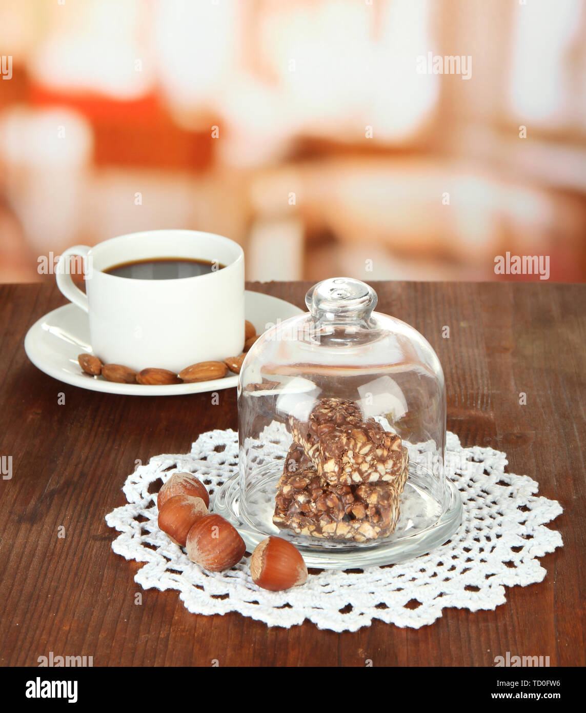 Chocolate sweets under glass cover and hot drink on bright background ...