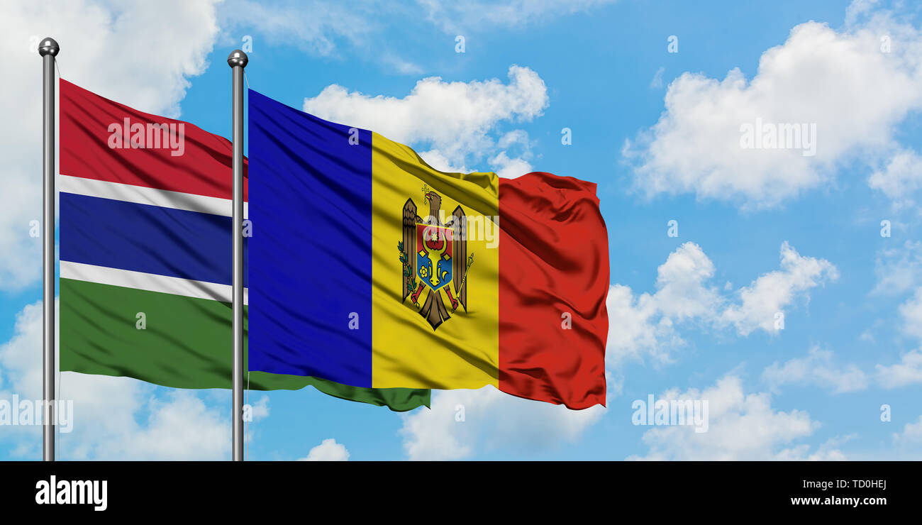 Gambia and Moldova flag waving in the wind against white cloudy blue ...