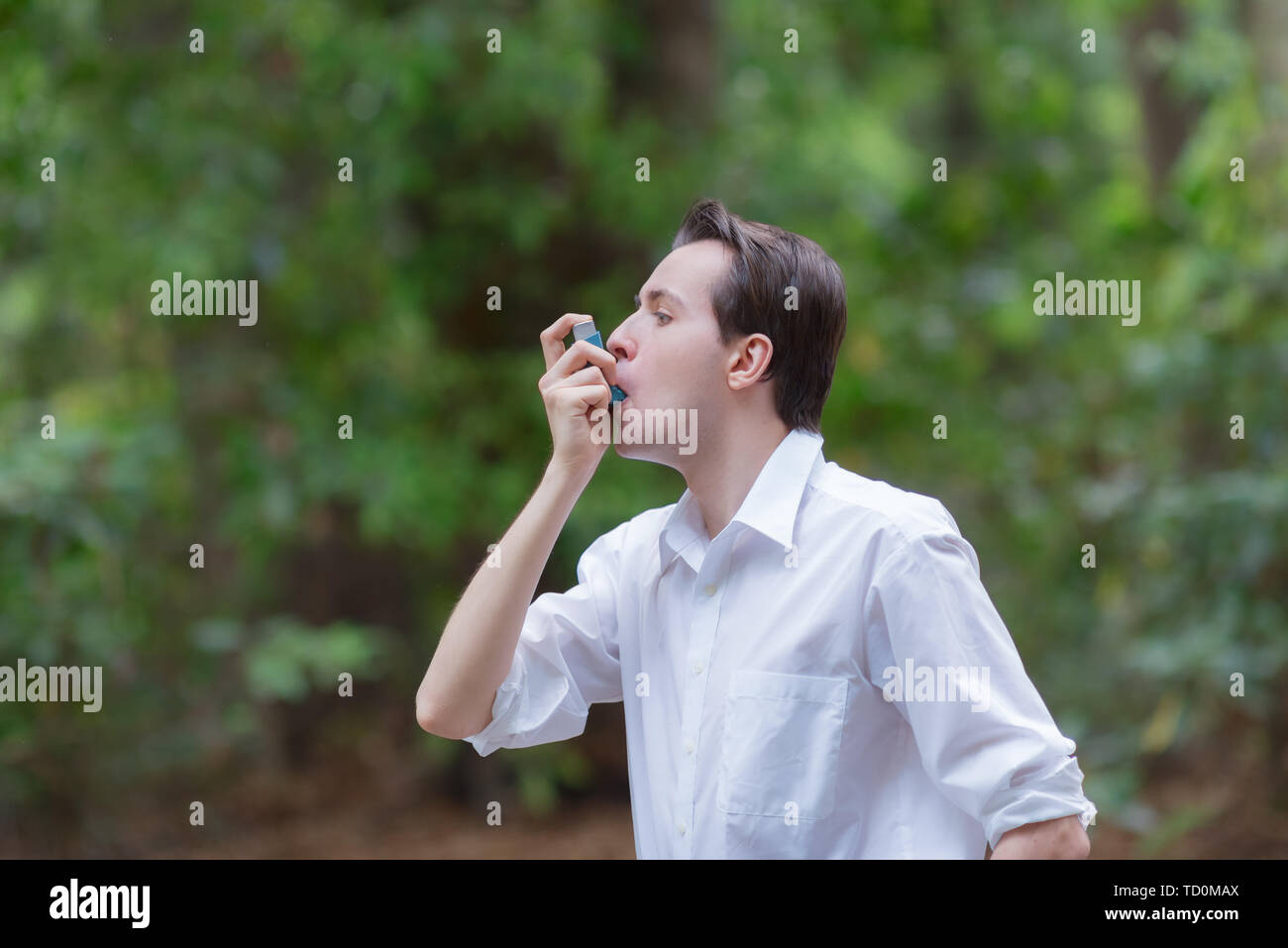 Young man is using a asthma inhaler Stock Photo - Alamy