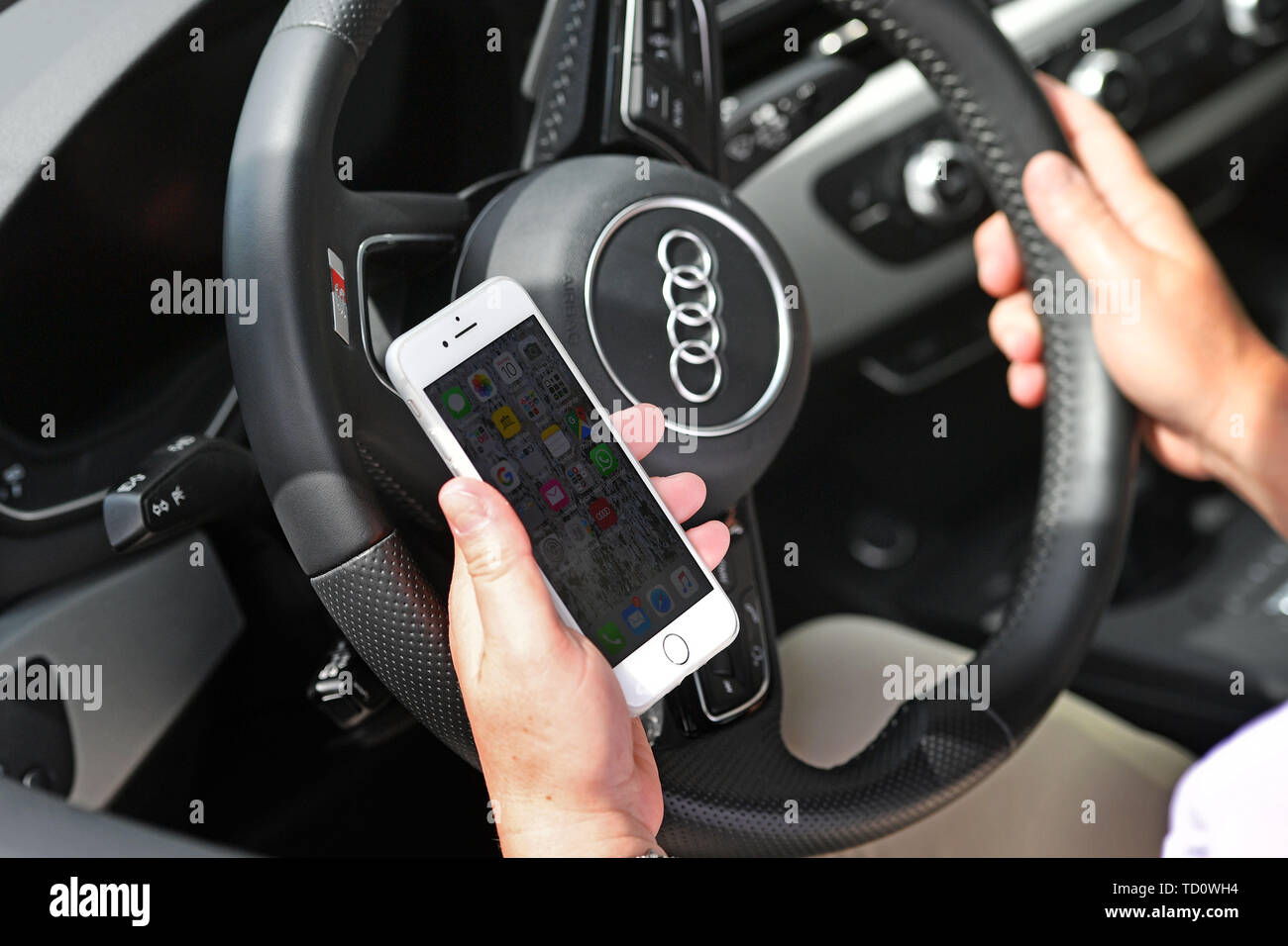 Munich, Deutschland. 10th June, 2019. Using a mobile phone at the wheel ...