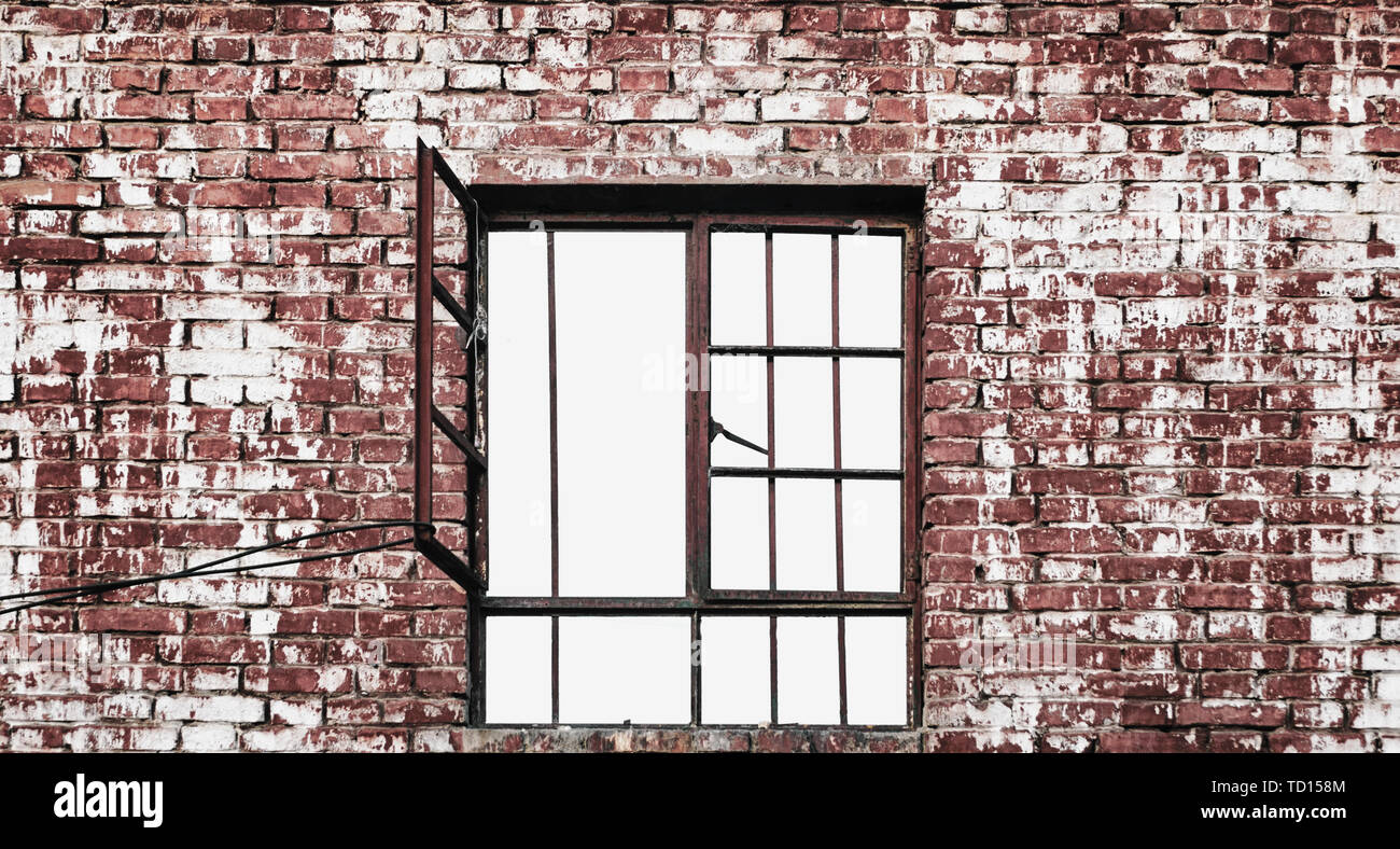 On one side is a red brick wall with a broken window Stock Photo - Alamy