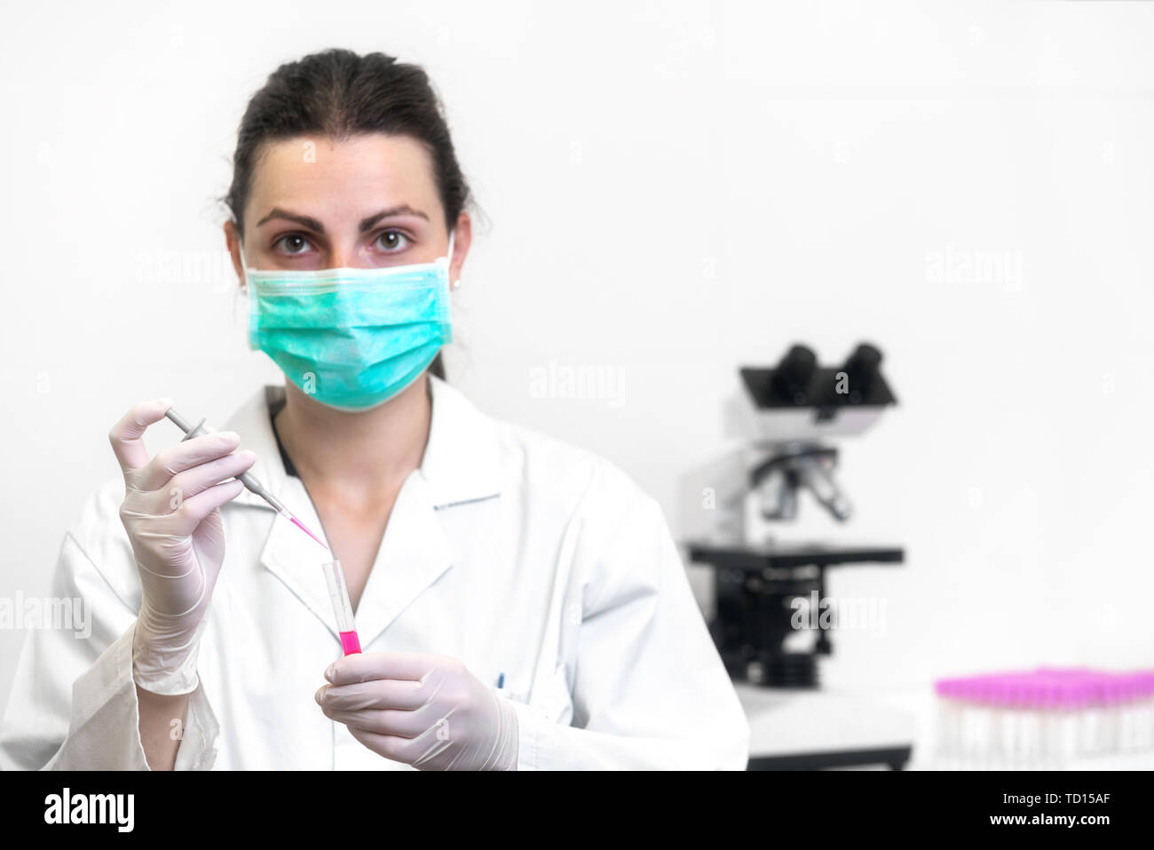 Cheerful female scientist with protective mask posing at the laboratory ...