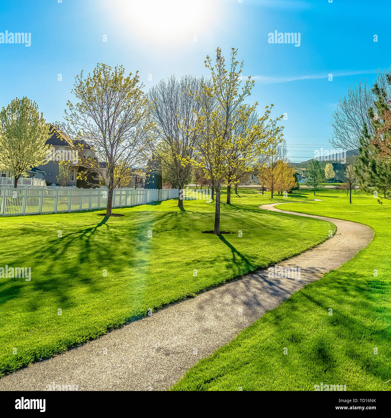 Square Pathway curving on a grassy terrain under the blazing sun and ...