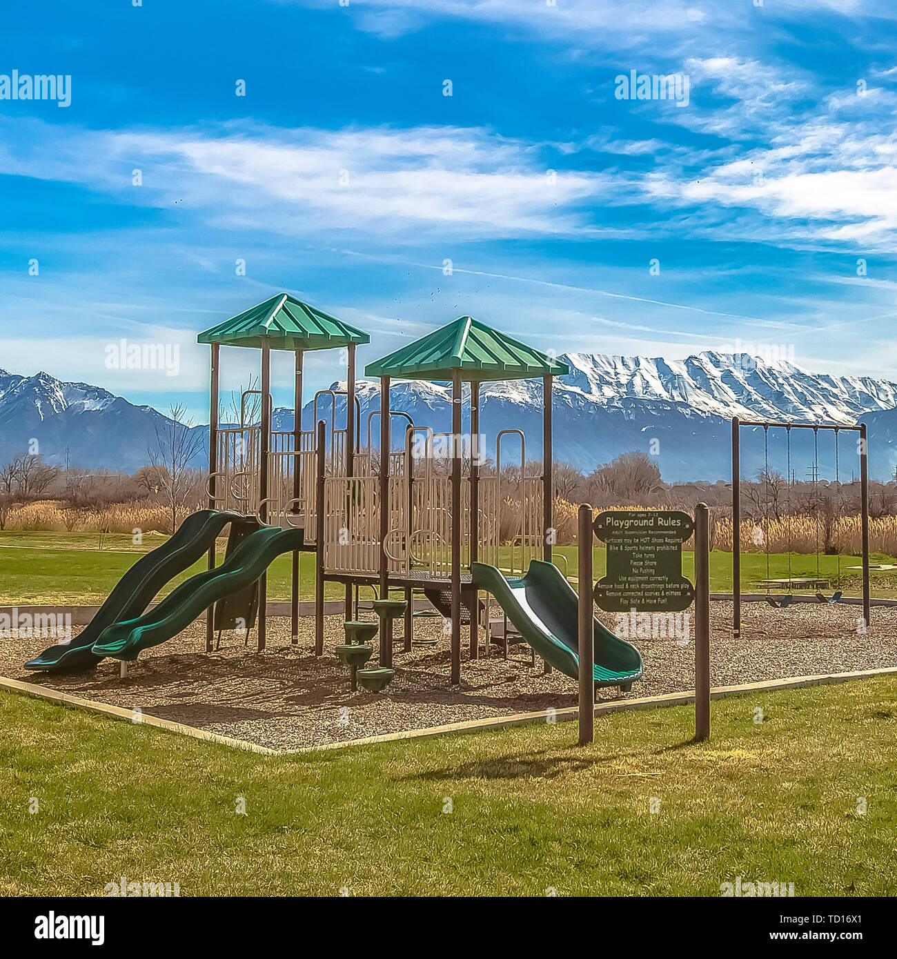 Square Slides and swings on a playground under bright blue sky on a ...