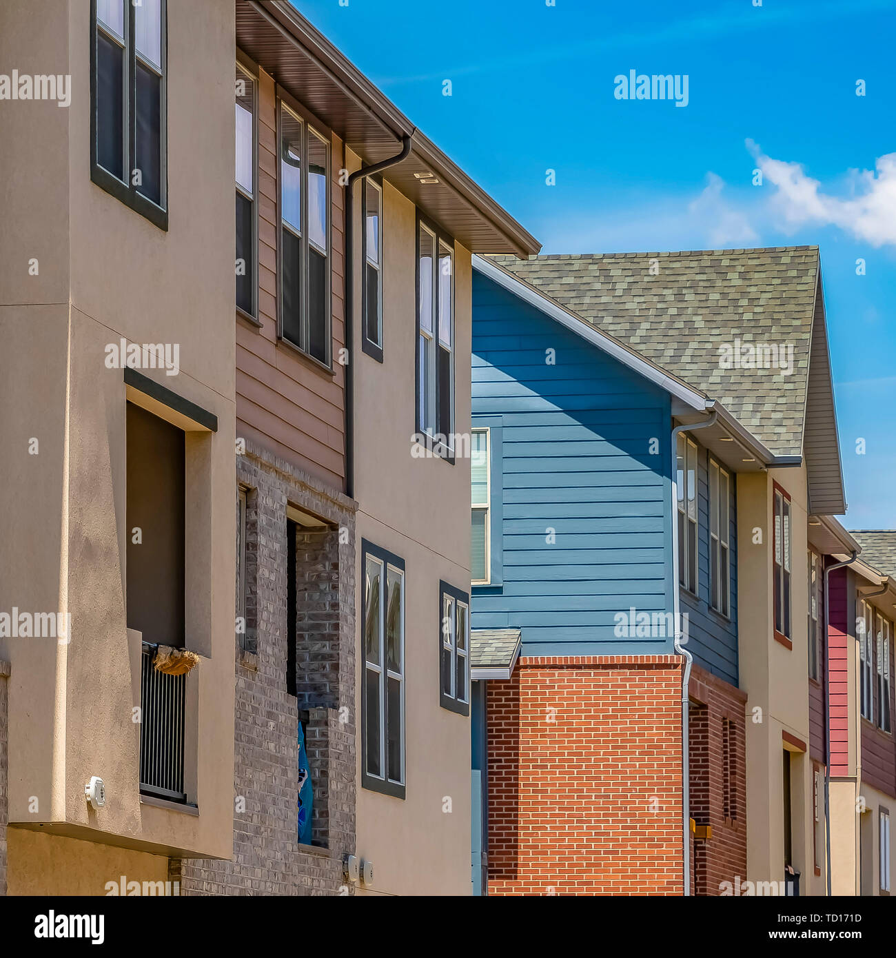 Square Exterior of townhouses against bright blue sky on a sunny day ...
