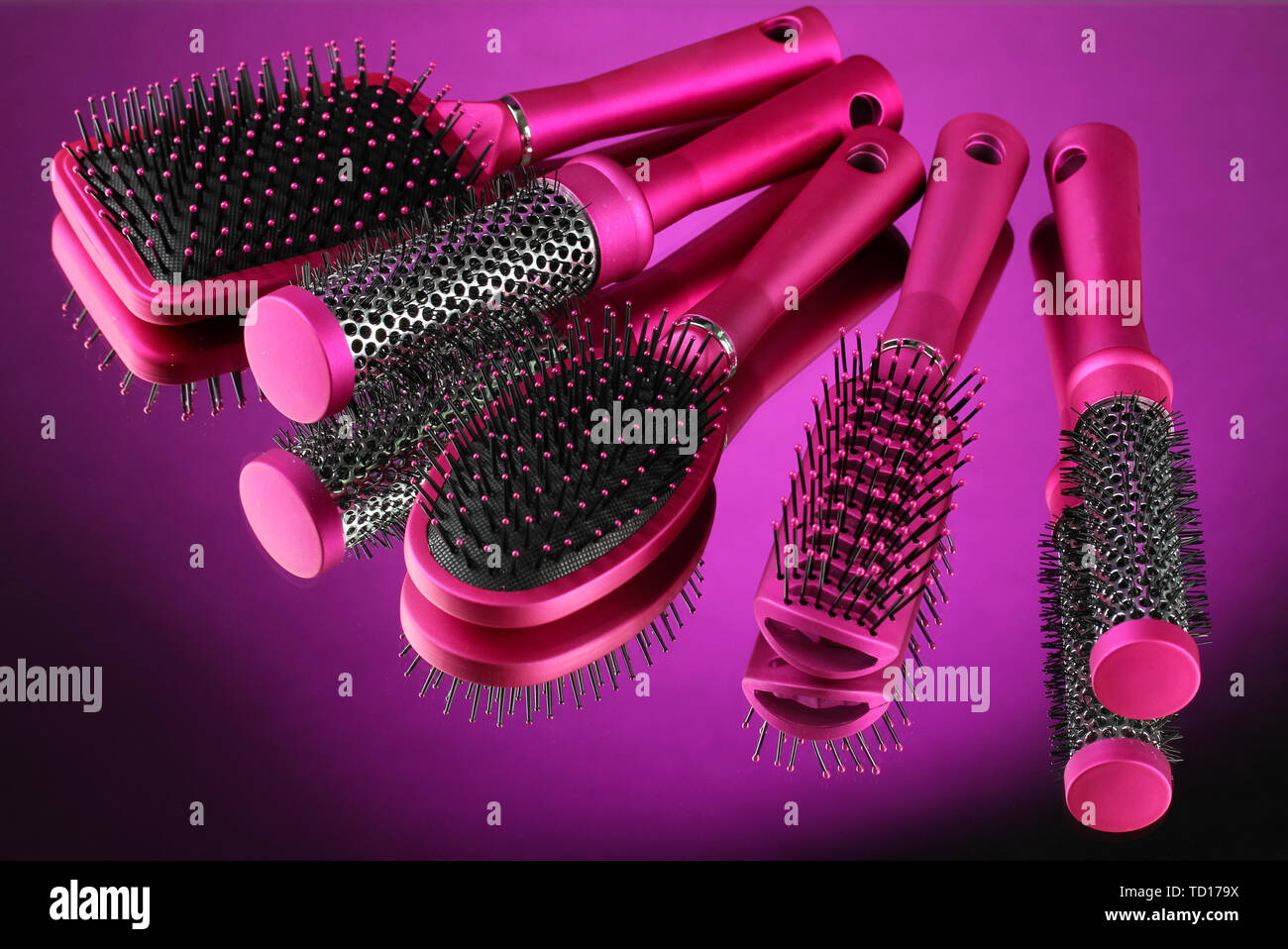 Comb brushes on purple background Stock Photo - Alamy