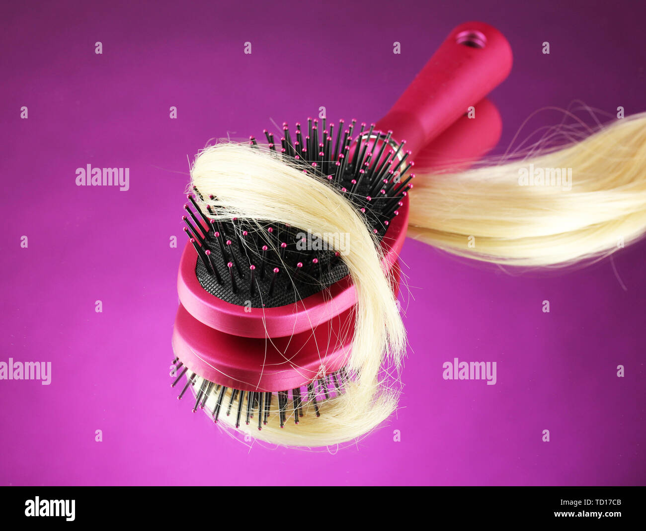 Comb brush with hair on purple background Stock Photo - Alamy