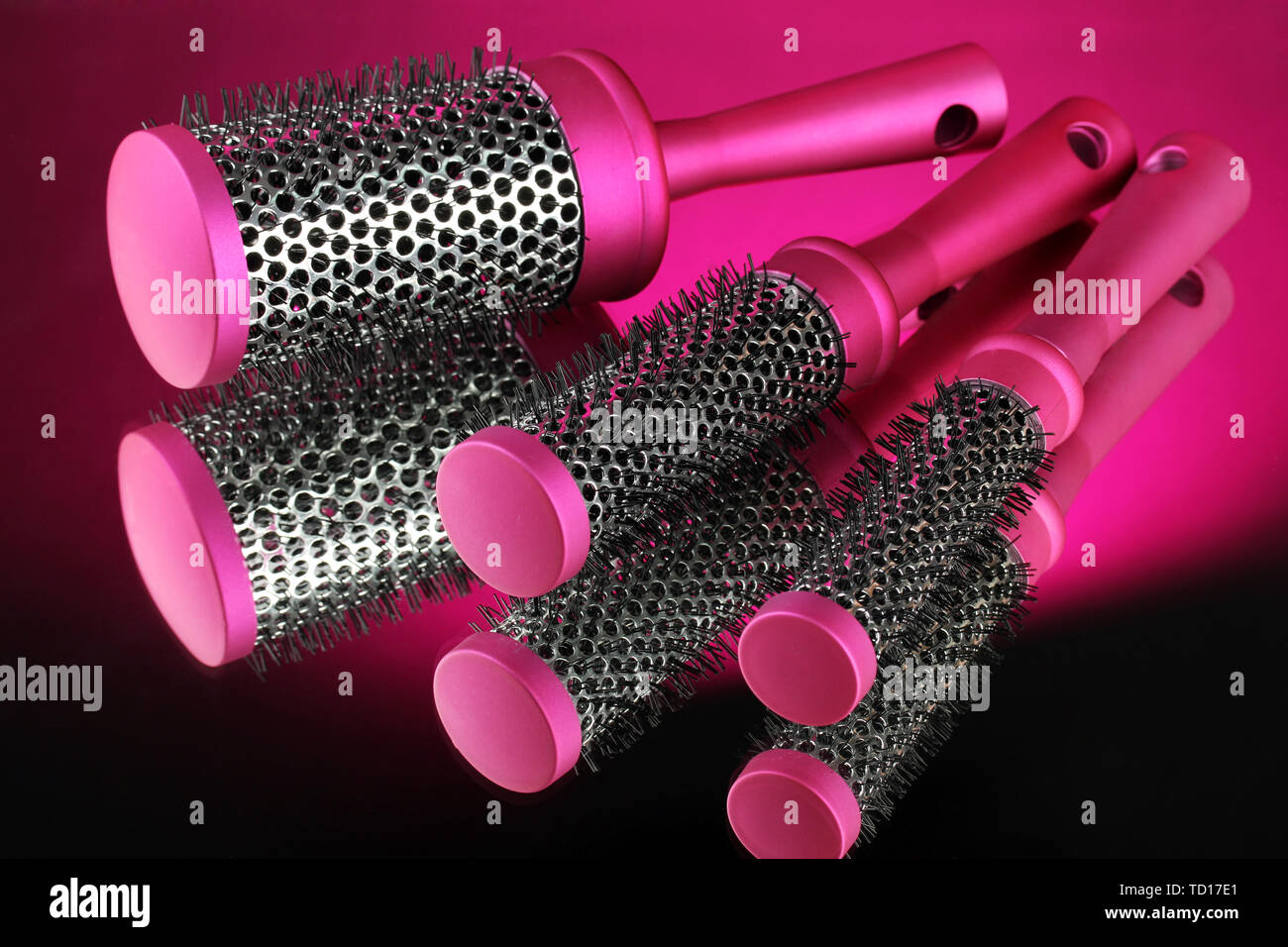 Comb brushes on pink background Stock Photo - Alamy