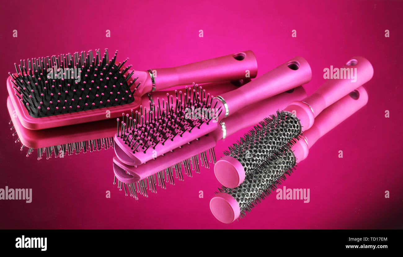 Comb brushes on pink background Stock Photo - Alamy