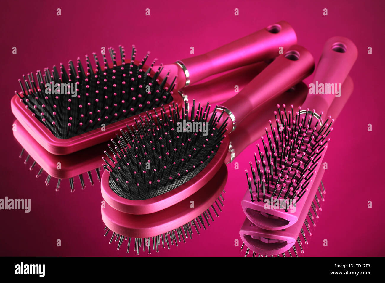 Comb brushes on pink background Stock Photo - Alamy