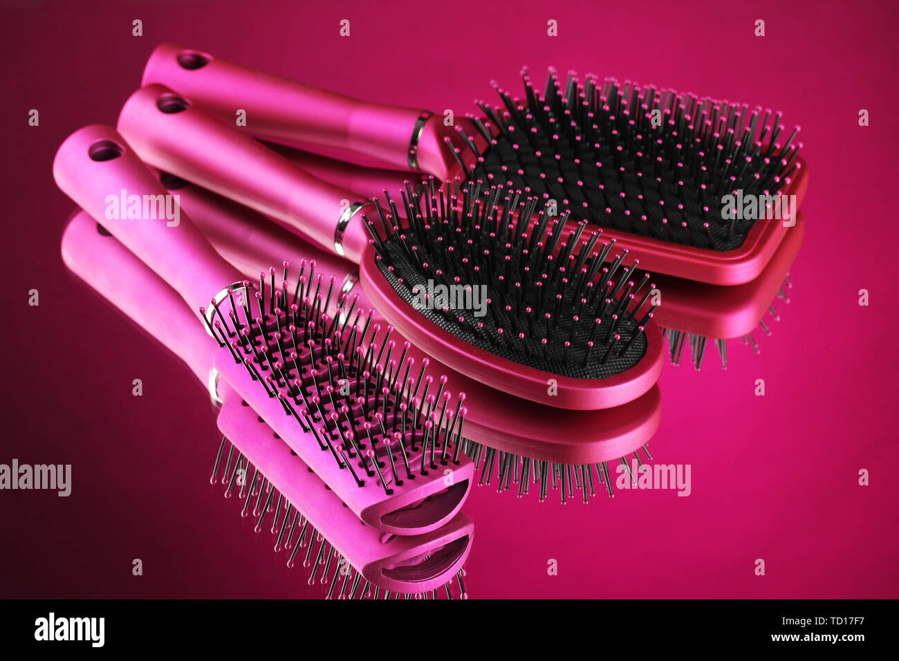 Comb brushes on pink background Stock Photo - Alamy