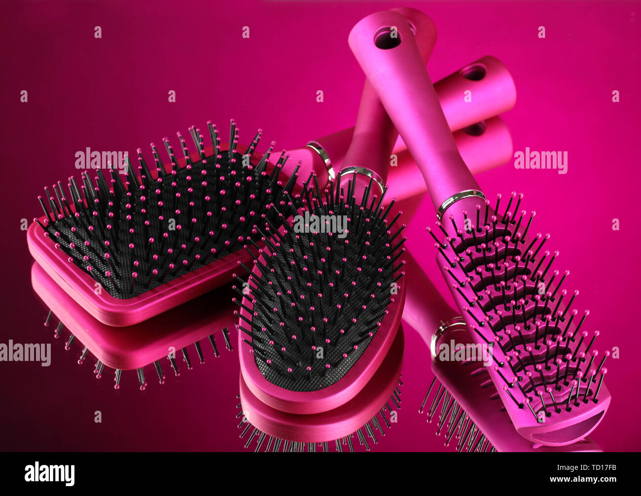 Comb brushes on pink background Stock Photo - Alamy
