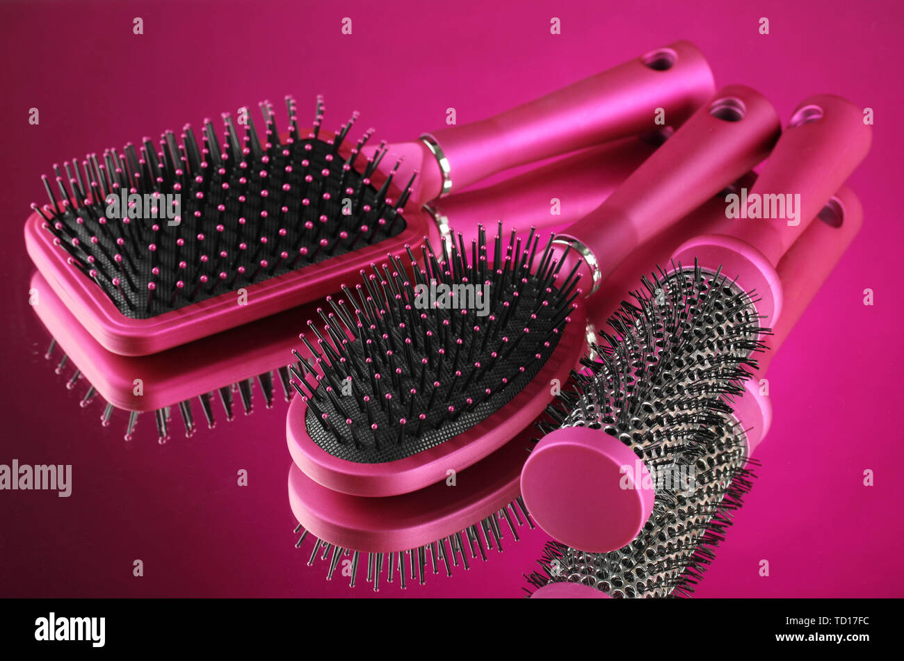 Comb brushes on pink background Stock Photo - Alamy