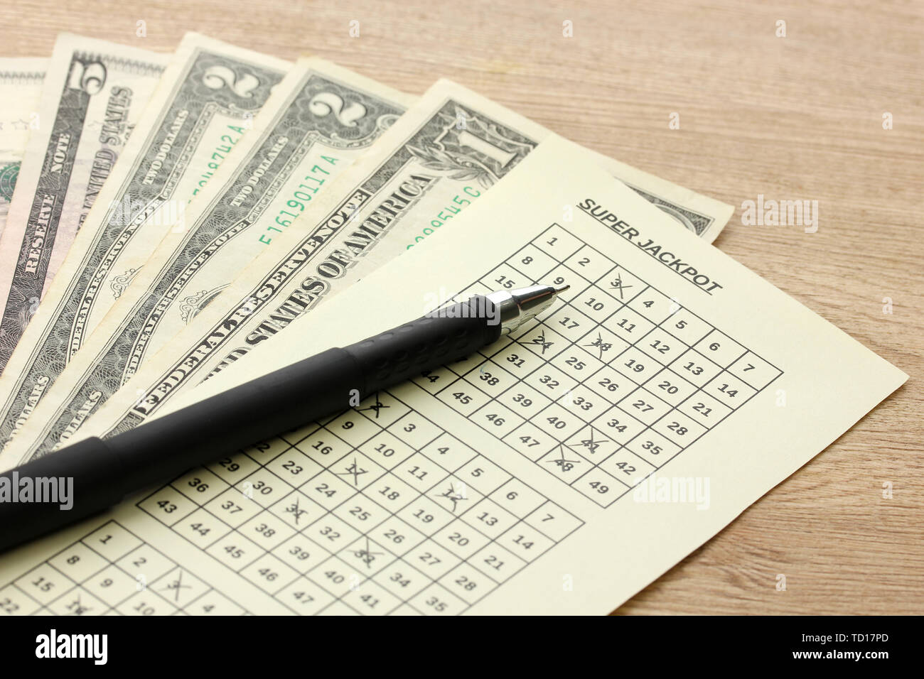 Lottery ticket with pen and money, on wooden background Stock Photo - Alamy