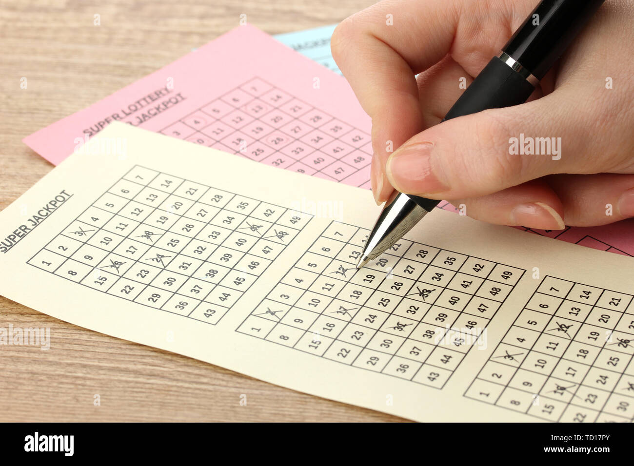 Closeup of lotto ticket during the marking of numbers, on wooden ...