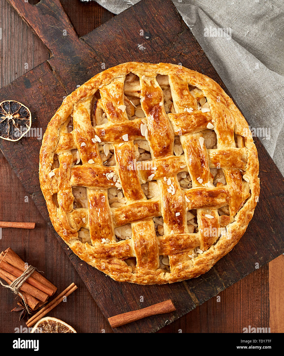 baked whole round apple pie on a brown wooden board, puff pastry, top ...