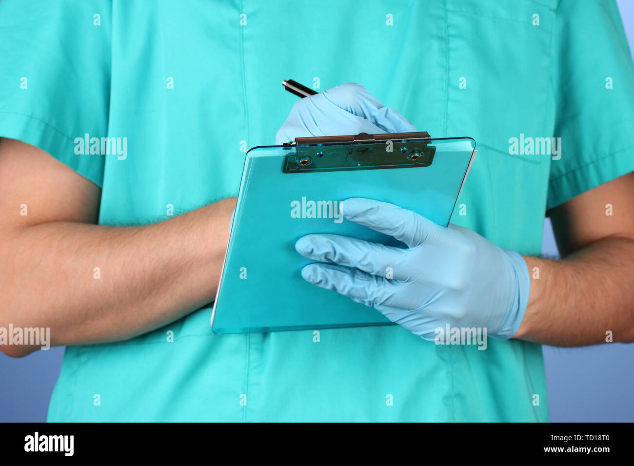 Hand of doctor with pen writing on prescription blank, on blue ...