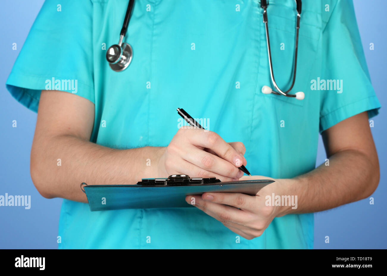 Hand of doctor with pen writing on prescription blank, on blue ...