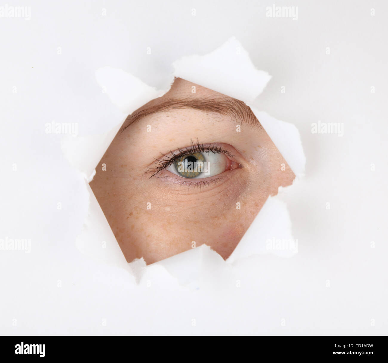 Female eye looking through hole in sheet of paper Stock Photo - Alamy