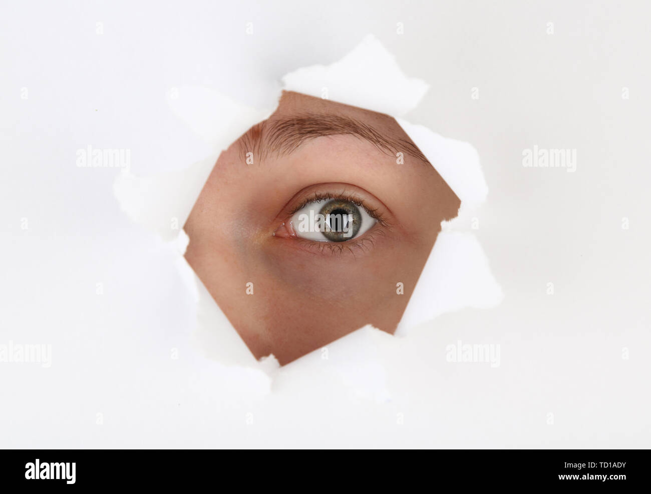 Female eye looking through hole in sheet of paper Stock Photo - Alamy