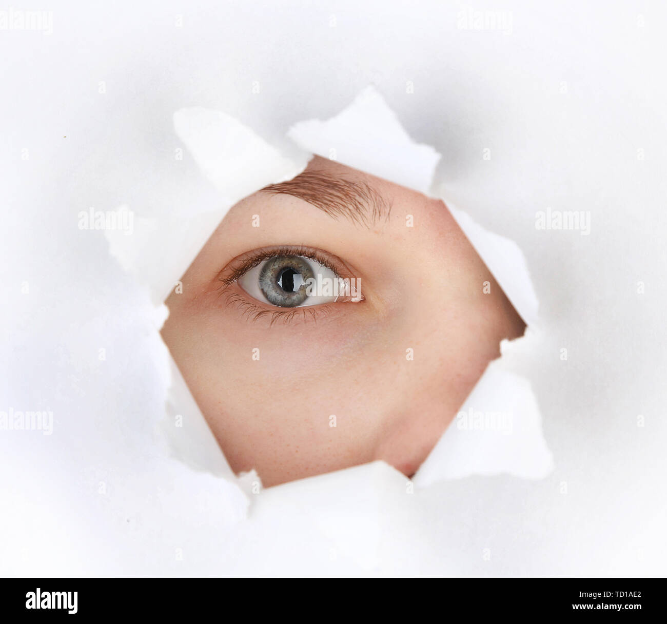 Female eye looking through hole in sheet of paper Stock Photo - Alamy