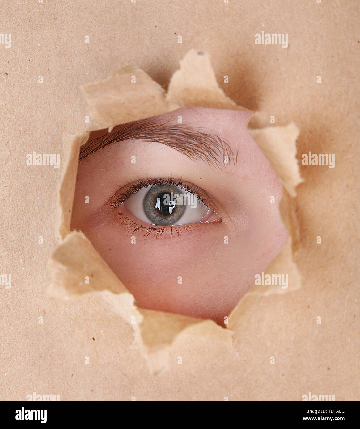 Female eye looking through hole in sheet of paper Stock Photo - Alamy