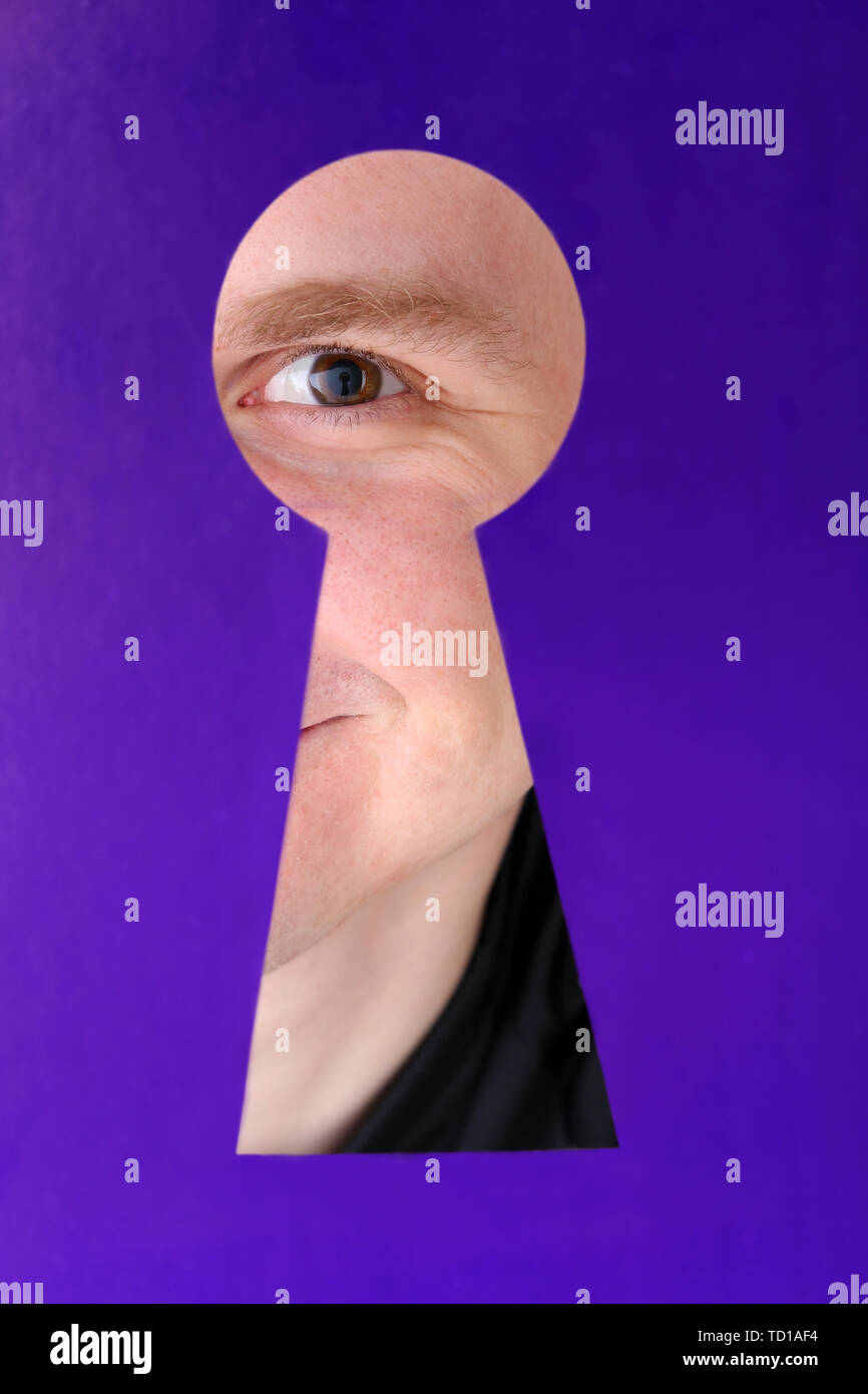 Man eye looking through hole in keyhole, on blue background Stock Photo ...