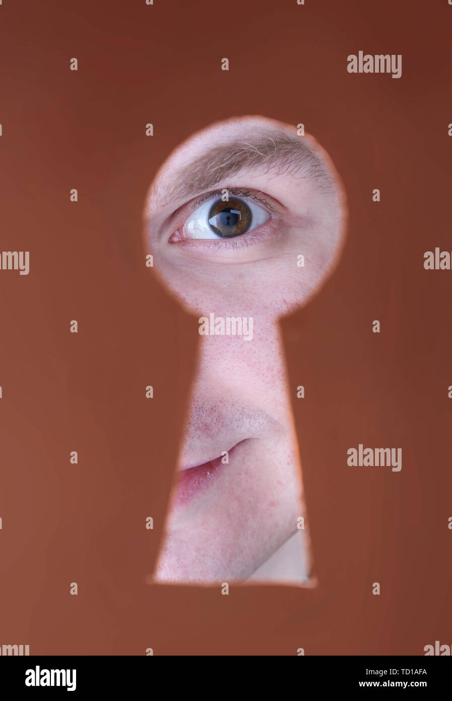 Man eye looking through hole in keyhole, on brown background Stock ...
