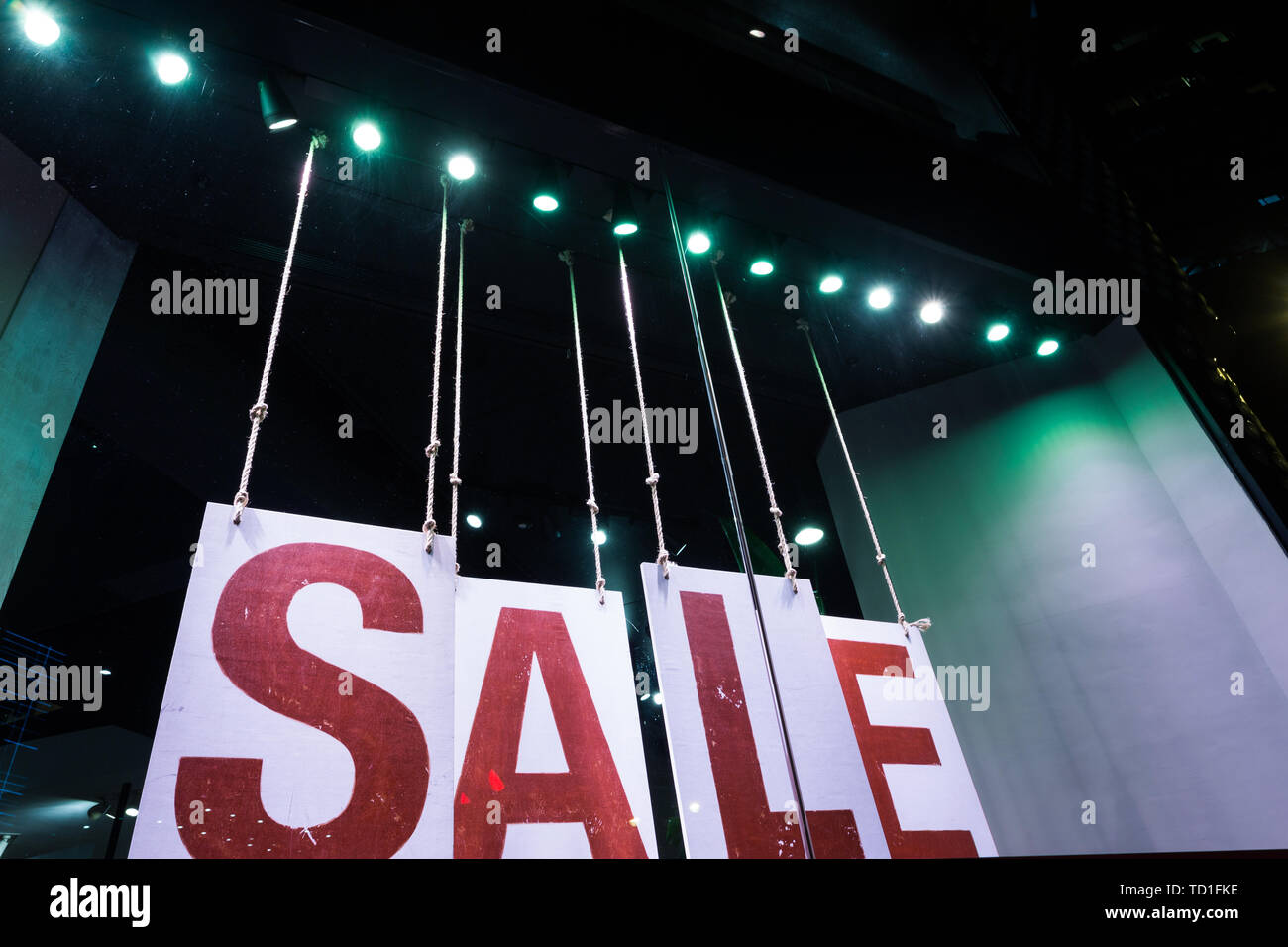 sale poster in fashion shop display window Stock Photo - Alamy
