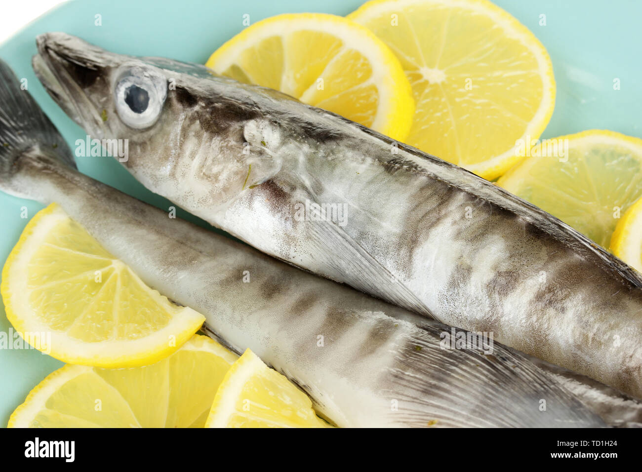 Fresh fish with lemon on plate close-up Stock Photo - Alamy