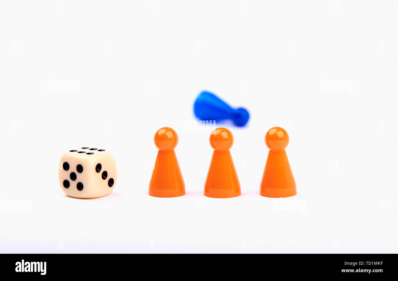 Three orange game pieces with a dice and a blue figure lying behind ...