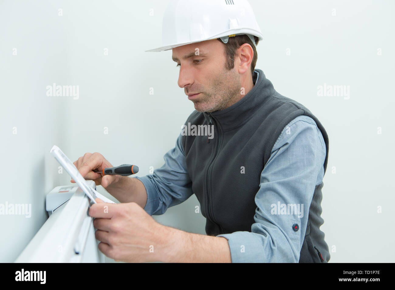 plumber fixing a radiator Stock Photo - Alamy