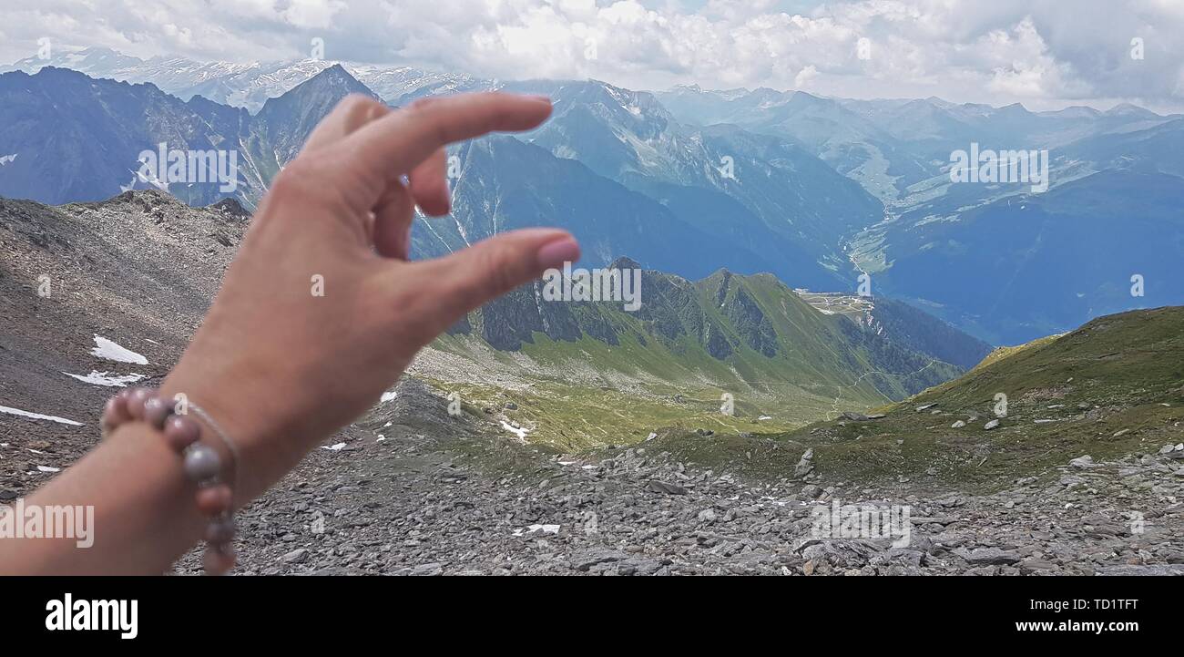 hand reaching for mountains during fog and rain, evening or morning ...