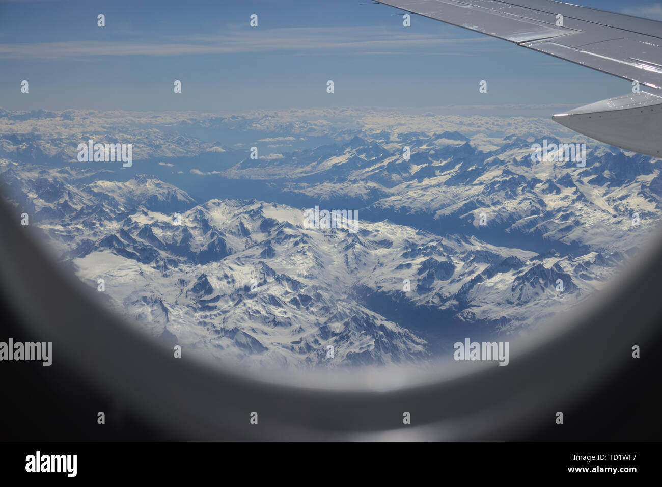Snow covered mountains (alps) and clouds seen through window of an ...