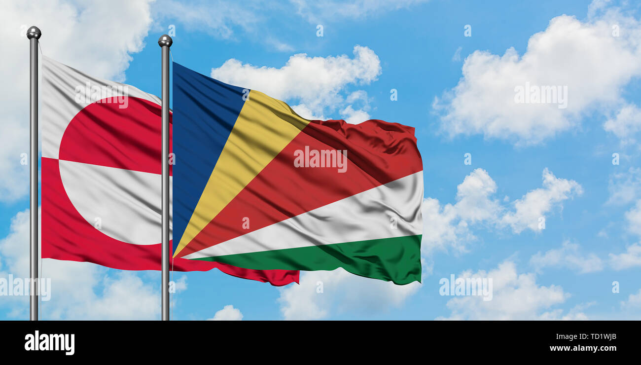 Greenland and Seychelles flag waving in the wind against white cloudy blue sky together ...