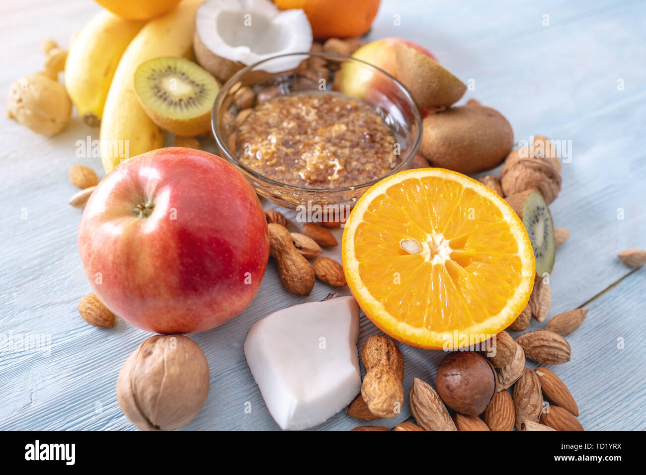 Healthy vegan raw foods on blue wooden background. Fruits and nuts with ...