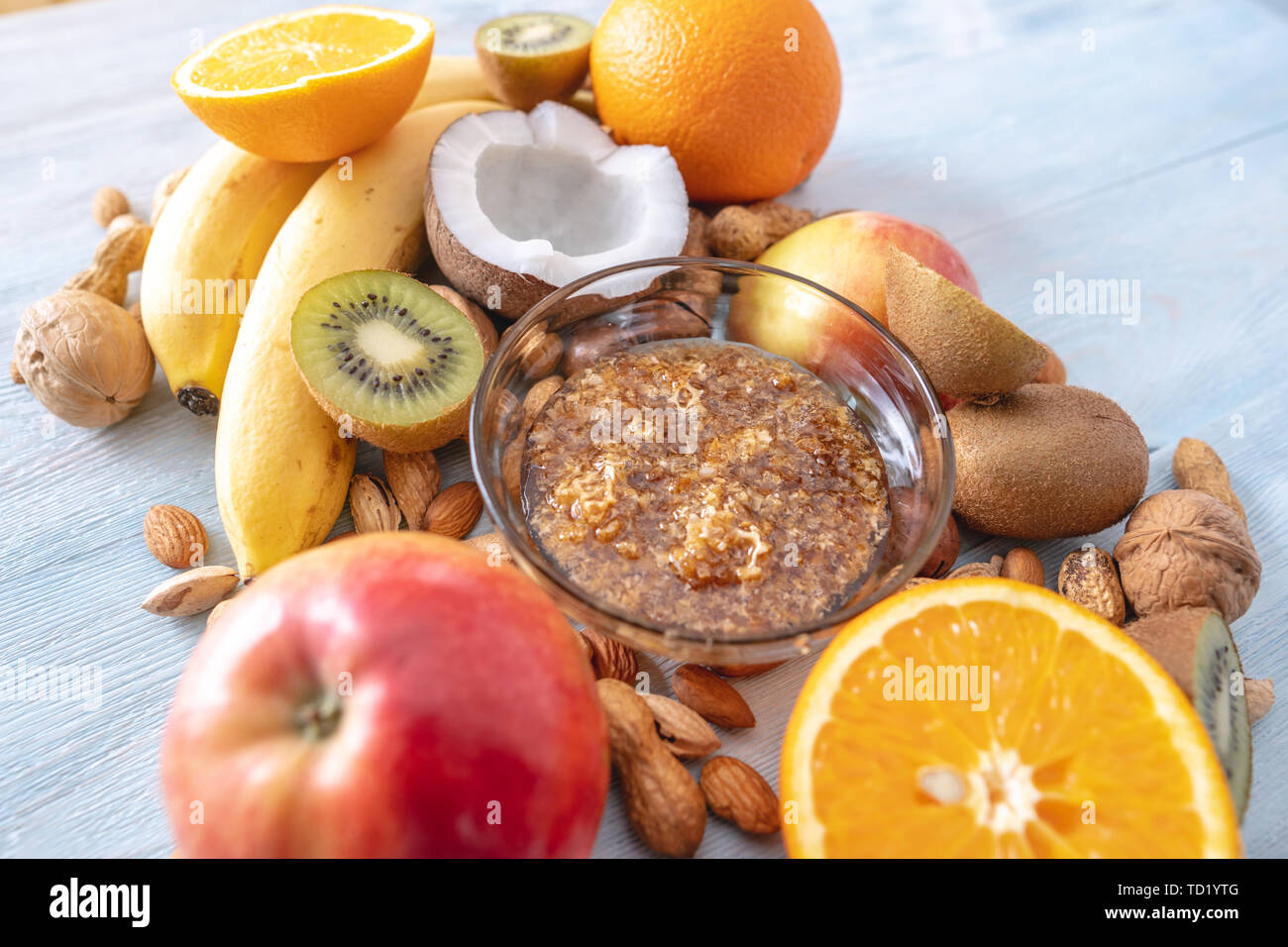 Healthy vegan raw foods on blue wooden background. Fruits and nuts with ...