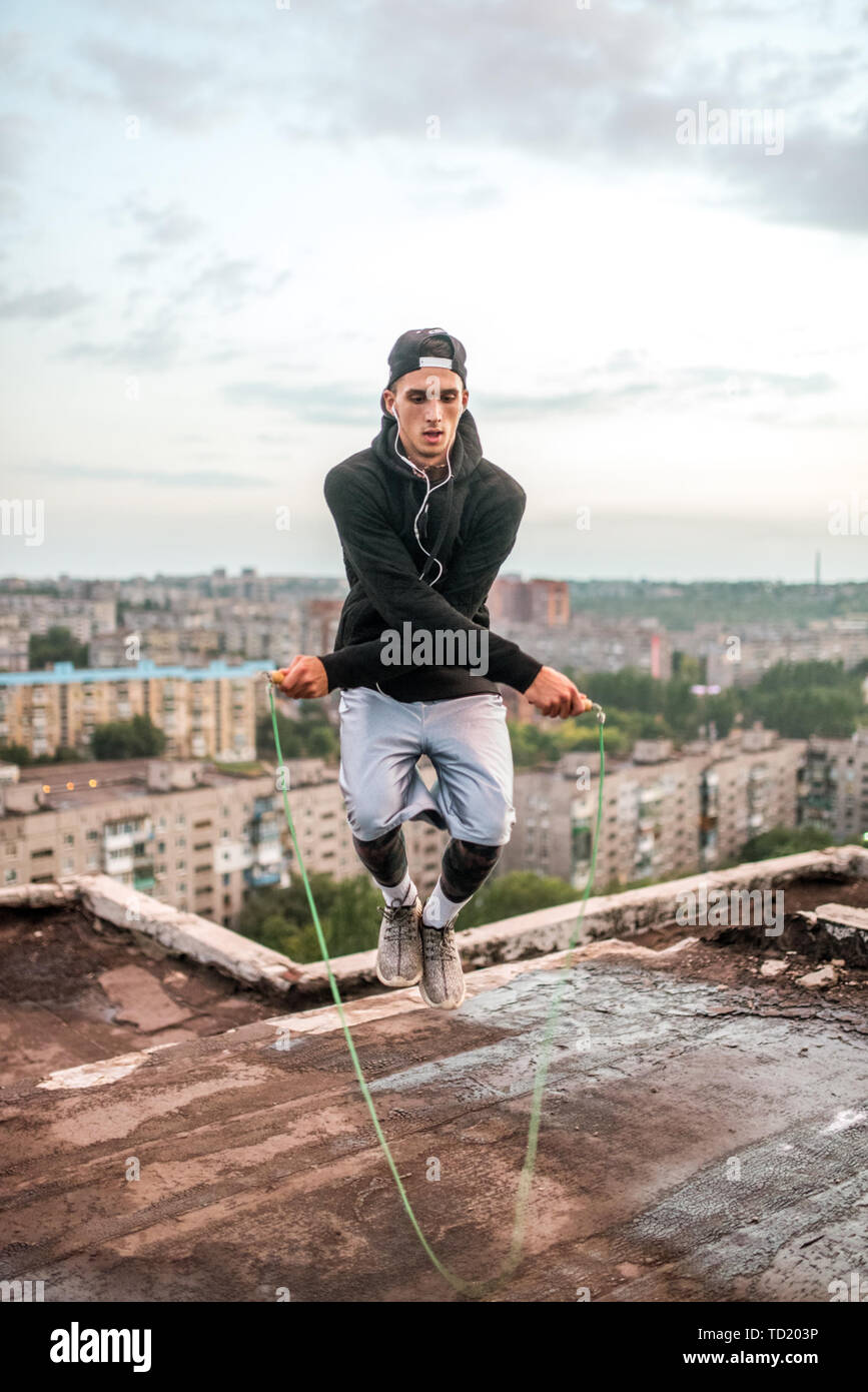exercising and lifestyle concept - man skipping with jump rope outdoors ...