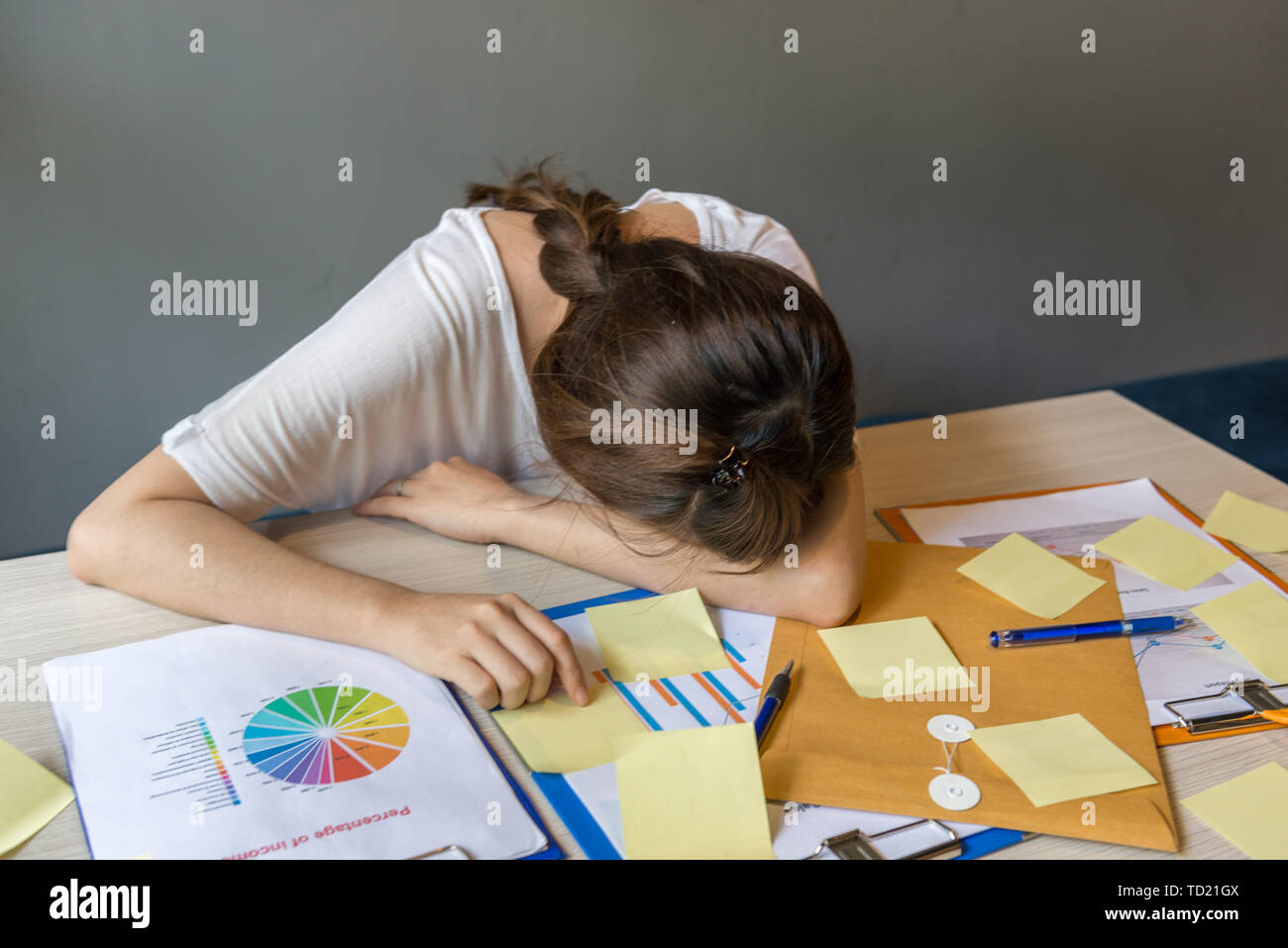 Tired office woman fall asleep on unorganized table Stock Photo - Alamy