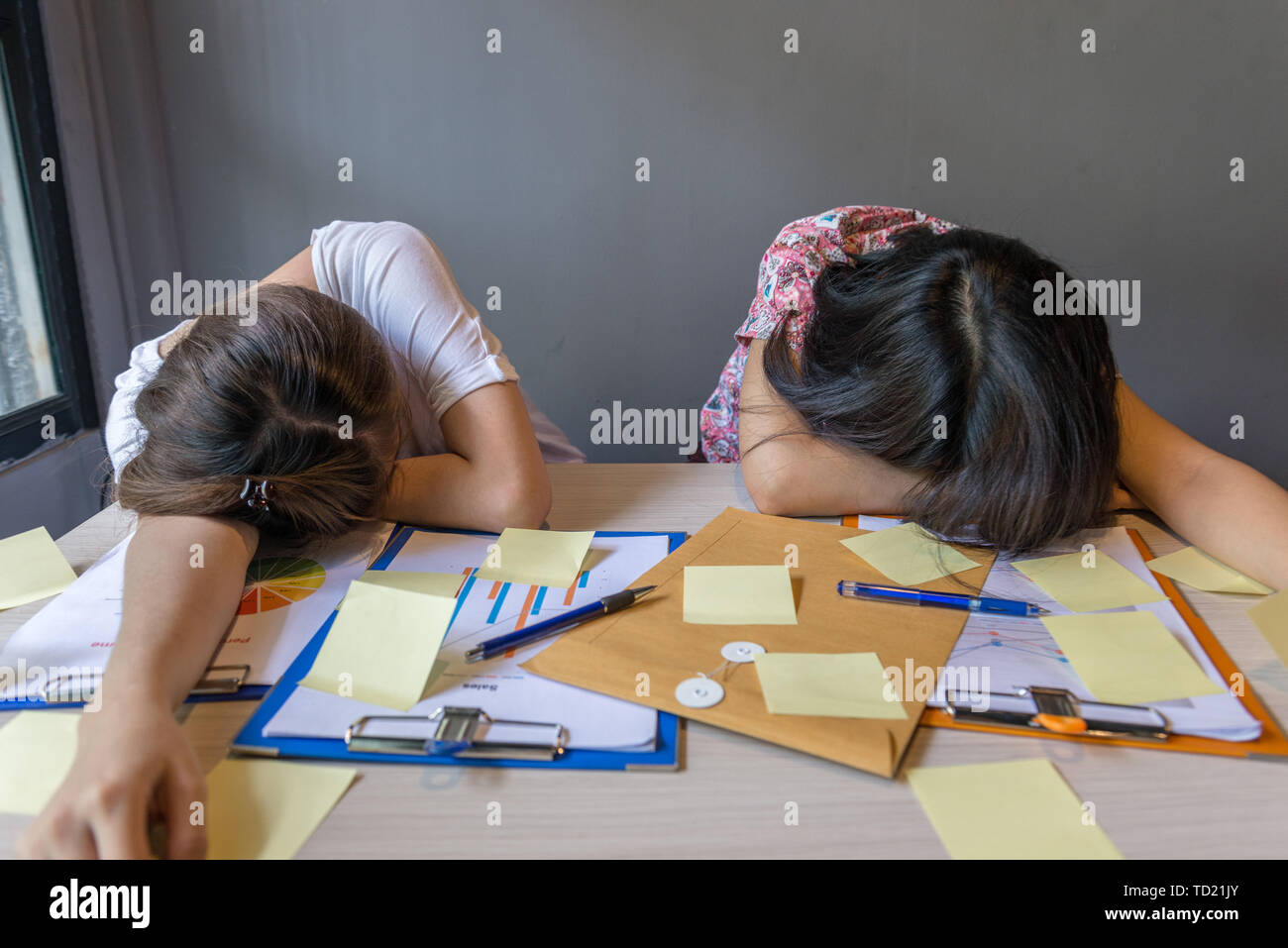 Tired women sleeping on desk full sticky notes Stock Photo - Alamy
