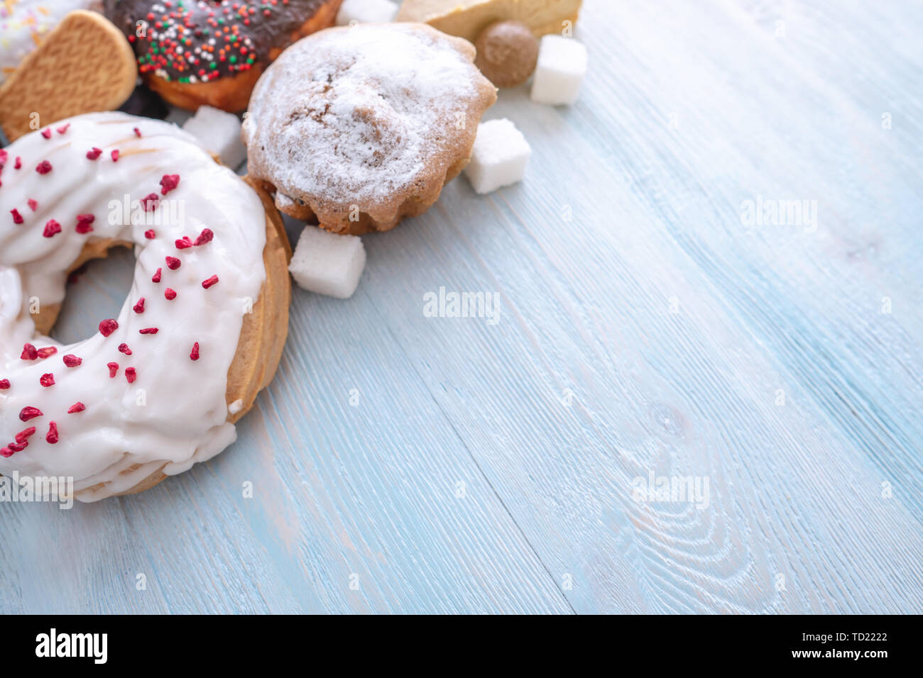 Harmful sweet foods on blue wooden background. Donuts, muffins ...