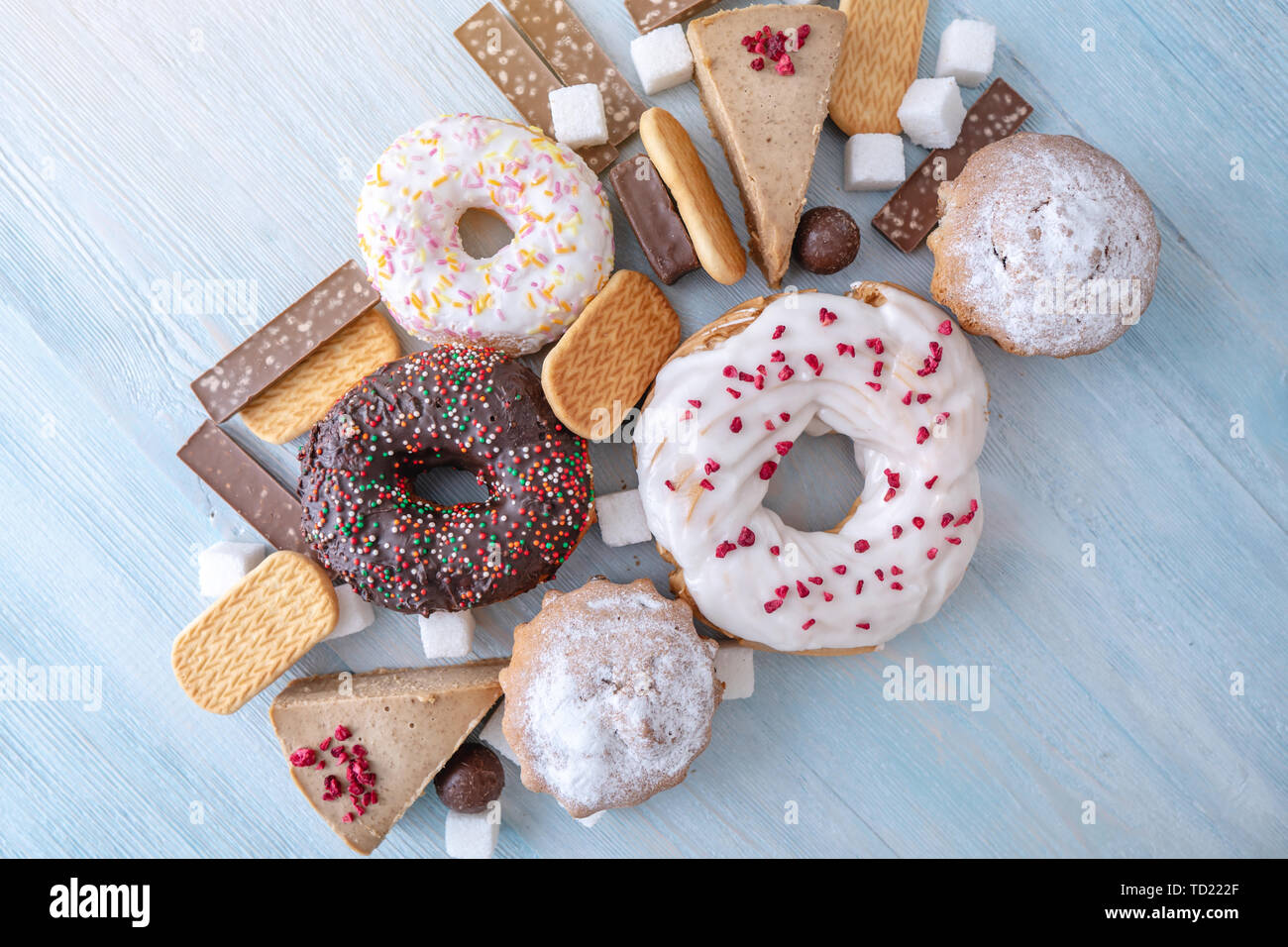 Harmful sweet foods on blue wooden background. Donuts, muffins ...