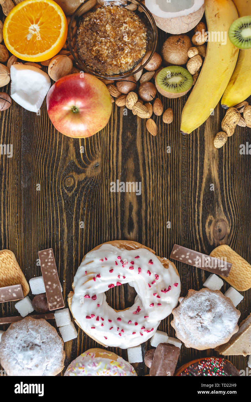 Unhealthy and healthy sweets on wooden background. Organic and dietary ...
