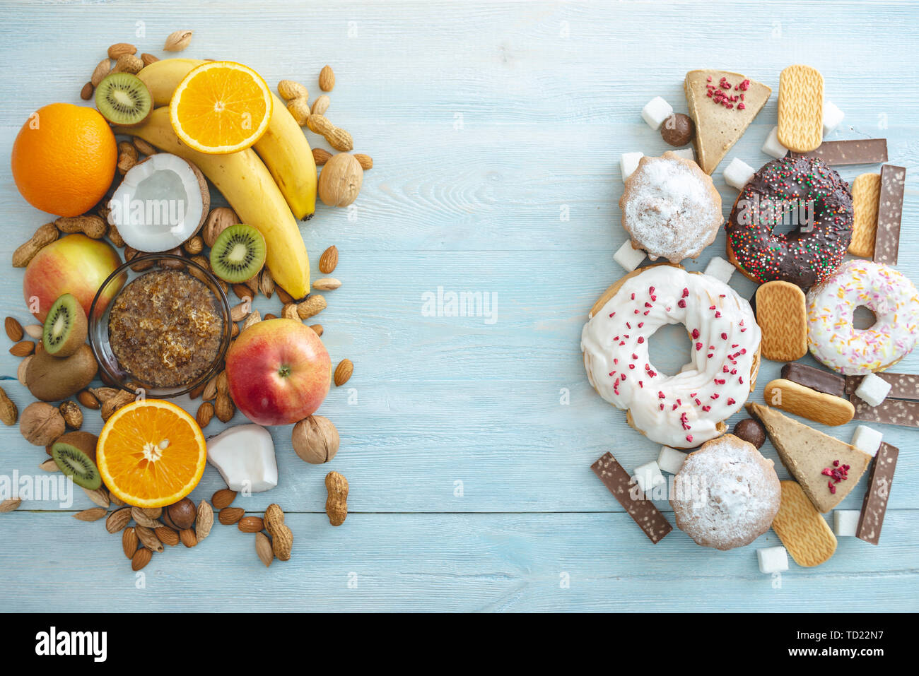 Unhealthy and healthy sweets on blue wooden background. Organic and ...