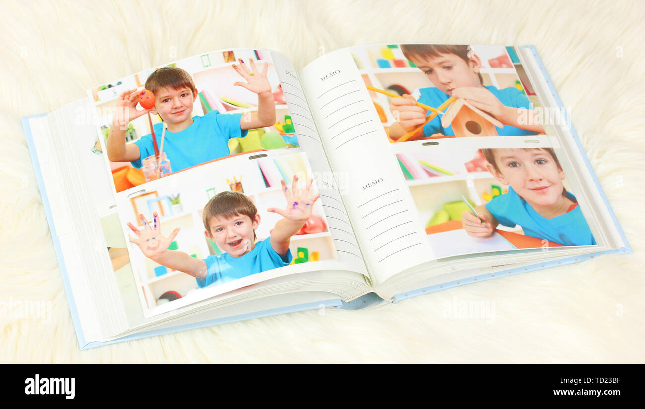 Open photo album with pictures on white carpet Stock Photo - Alamy