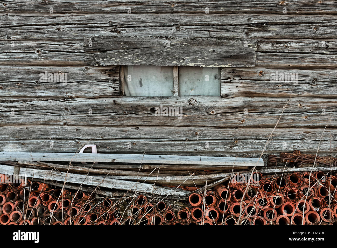 A window in an old wooden barn house at the rural Finland. The pipes ...