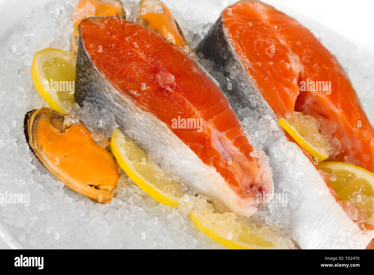 Pieces of red fish on ice in plate isolated on white Stock Photo - Alamy