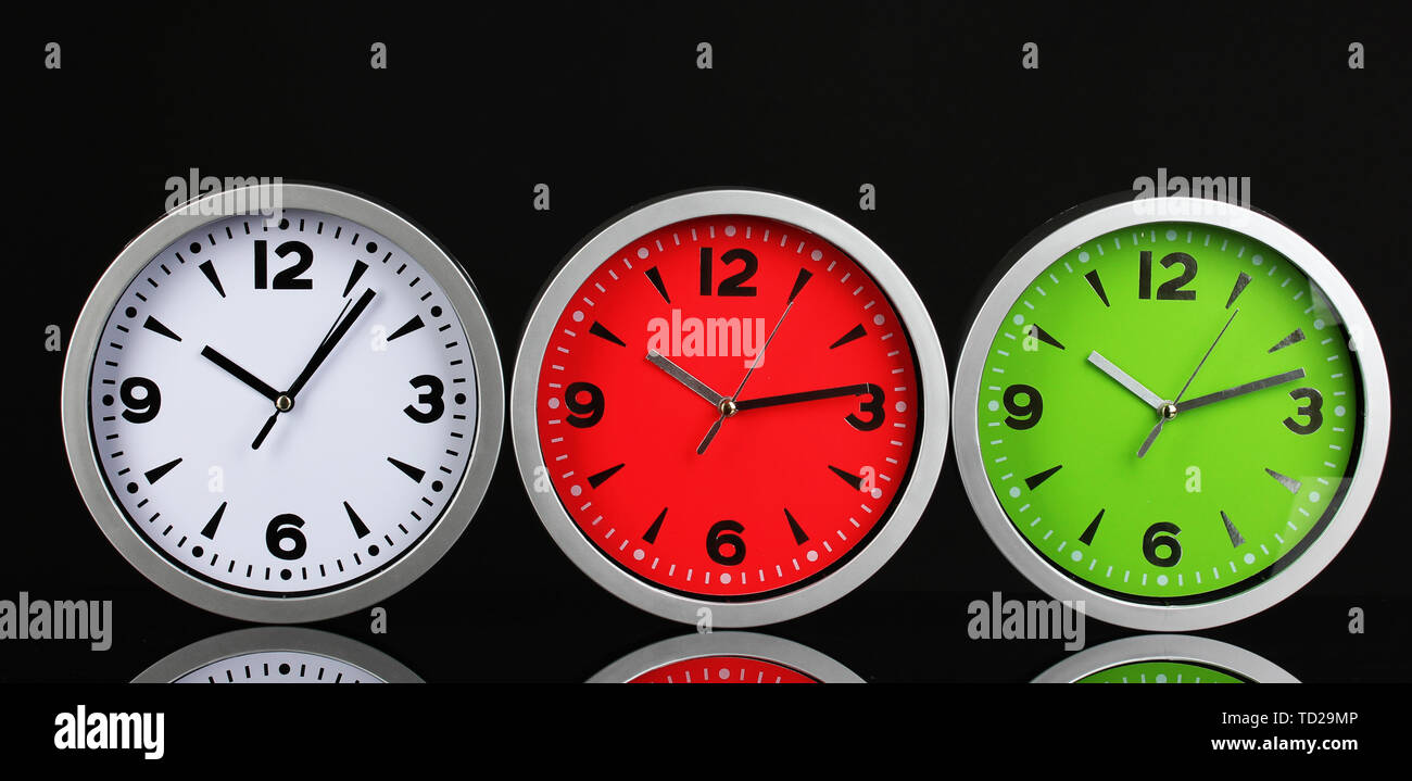 Round office clocks on black background Stock Photo - Alamy