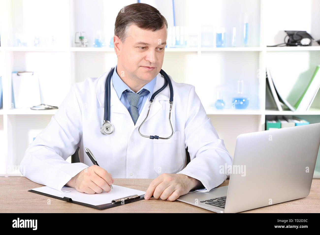 Medical doctor working at desk Stock Photo - Alamy