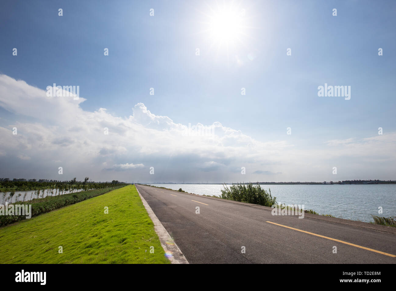 Empty road near river in blue sunnysky Stock Photo - Alamy